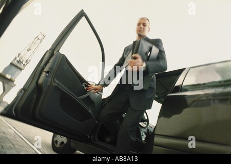 Businessman getting out of a car Stock Photo - Alamy