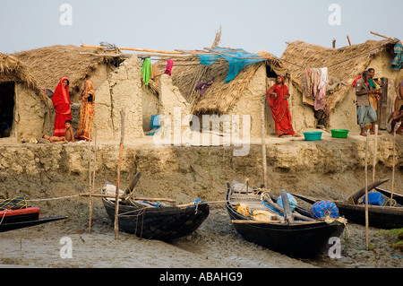 Poor fishing village and thatched roof mud houses along Passur River ...