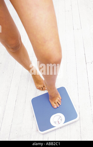 Female leg is stepping on white scales at home Stock Photo - Alamy