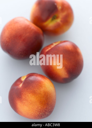 four nectarines on orange yellow background Stock Photo - Alamy
