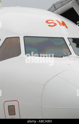 Commercial airline nose of plane and cockpit windshield showing pilots ...