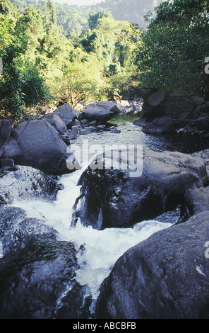 Small waterfalls of water tumbling over rocks downstream in a river on ...