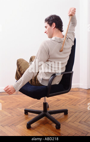 Businessman sitting on a chair, scratching his chin and thinking about ...