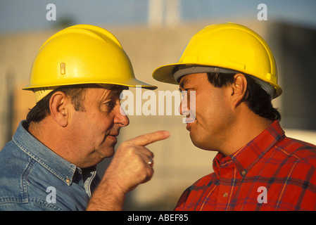 Two male construction workers fighting with tools and looking at each ...