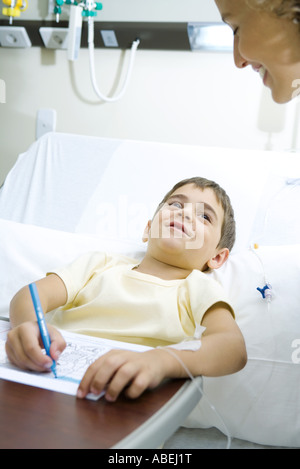 Boy lying on examination table, doctor feeling chest Stock Photo - Alamy