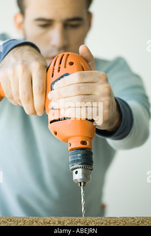 a young man drills wood Stock Photo - Alamy