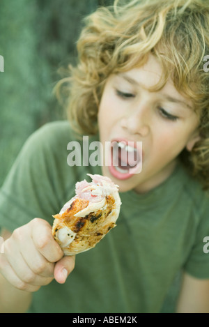 Portrait of a boy eating a chicken drumstick Stock Photo - Alamy