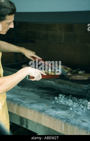 Man holds barbecue grill with meat and vegetables in hands. Summer ...