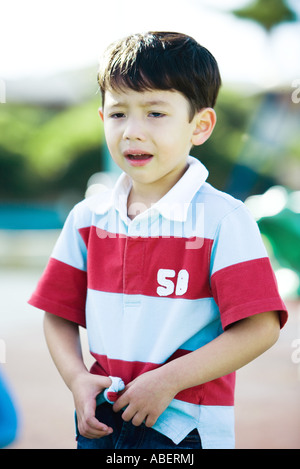 Unhappy boy in casual clothes crossing arms and looking away while ...