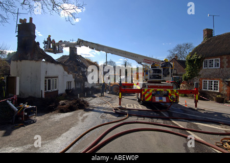 Firefighters at a burnt out cottage in Piddlehinton, Dorset, Britain ...