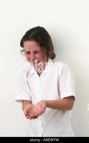 Girl holding out hand for smack and crying Stock Photo - Alamy