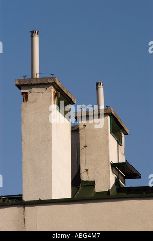 Rooftops and chimneys of modern guarded apartment houses with blue sky ...