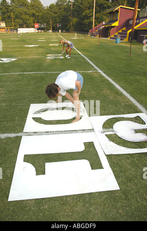 Volunteers Painting yardage numbers and logos on football fields in ...