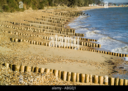 Wooden sea defences in front of eroded cliffs on the Norfolk coast ...