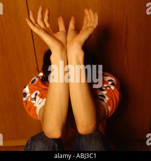 scared young man obscuring face with digital tablet isolated on blue ...