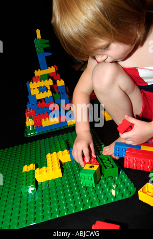 Young blond girl playing Lego toys on a carpet Stock Photo - Alamy