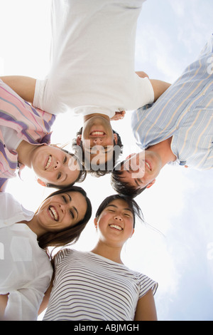 Group of happy male friends huddling, looking down at camera, smiling ...