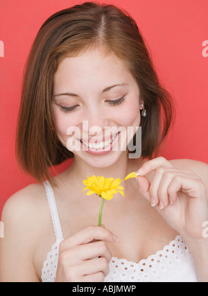 Girl pulling petals off a flower Stock Photo - Alamy