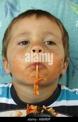 Young boy messily eating spaghetti Stock Photo - Alamy