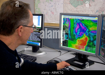 Meteorologist looking at weather maps from satellite data on computer ...