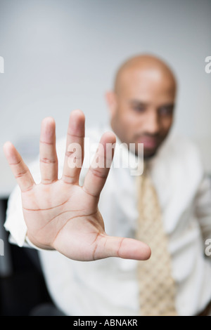 Businessman blocking camera with his hand Stock Photo - Alamy