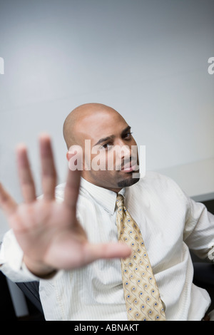 Businessman blocking camera with his hand Stock Photo - Alamy
