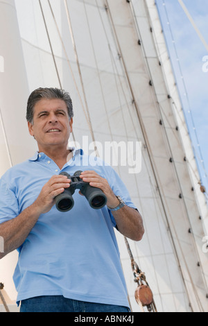 Man using binoculars on ship deck Stock Photo - Alamy