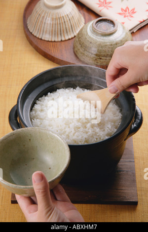 A woman serving steamed rice Stock Photo - Alamy