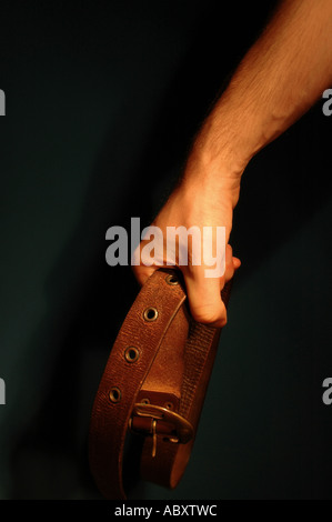 Man holding belt illustrating domestic violence Stock Photo - Alamy