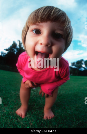 a cheeky girl pulling a funny face with angel on the top Stock Photo ...