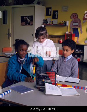Three primary school children in classroom Stock Photo - Alamy