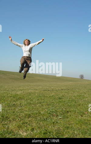 Woman jumping up in field Stock Photo - Alamy