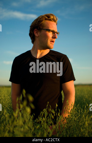 Musician Marcus Eaton at sunset in a field with guitar Stock Photo - Alamy