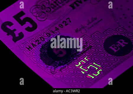 Banknote under ultraviolet light showing security features invisible in ...
