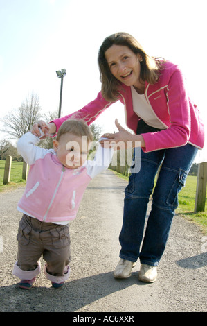 toddler walking with help from his mother Stock Photo - Alamy