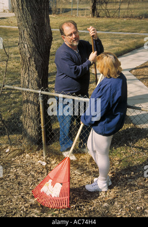Neighbors talking over the fence Stock Photo - Alamy