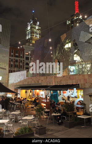 Cafe and square at Federation Square with city skyline in background ...
