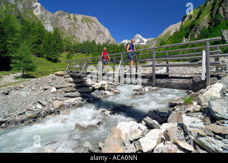 Wooden bridge above water with people walking Stock Photo - Alamy