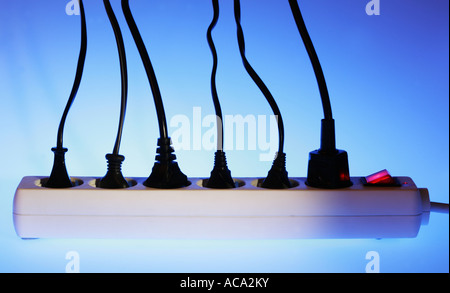 Side view of multiple electrical plugs on wooden floor near by the ...