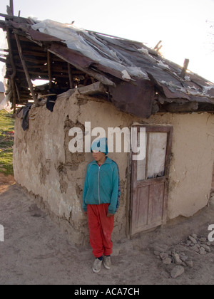 A resident stands in front of building damaged in an attack blamed by ...
