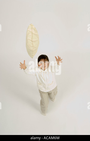 Girl throwing cushion Stock Photo - Alamy