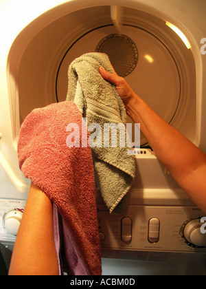 Woman removing towels from dryer Stock Photo - Alamy