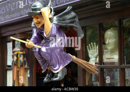 Halloween witch flying on a broomstick hanging outside a shop window ...