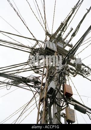 Tangled up electrical wires on pole against blue sky. Complex network ...