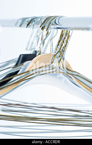 close up to hangers on the bar in cloth shop with a lot of people ...