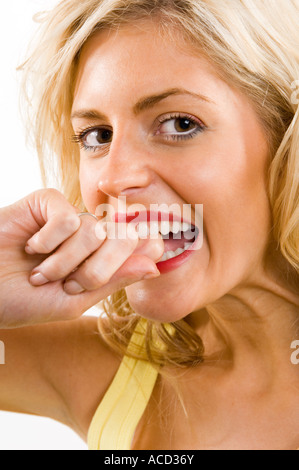 Woman biting her knuckle Stock Photo - Alamy