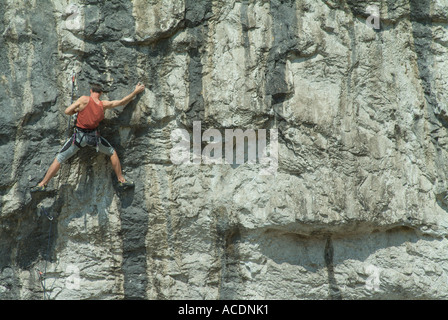 Malham cove climbers practising a climb up a vertical limestone cliff ...