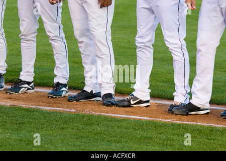 Feet of professional baseball players standing in a row along the first ...