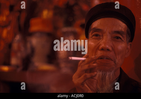 Asia Vietnam Buddhist monk smoking cigarette at small temple along Yen ...