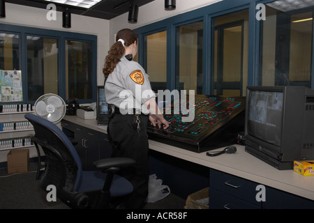 Female correctional officer monitoring cctv monitors. Diagnostics and ...